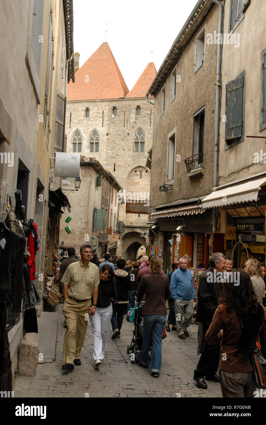 Tourists in a main narrow medieval street lined with tourist shops ...