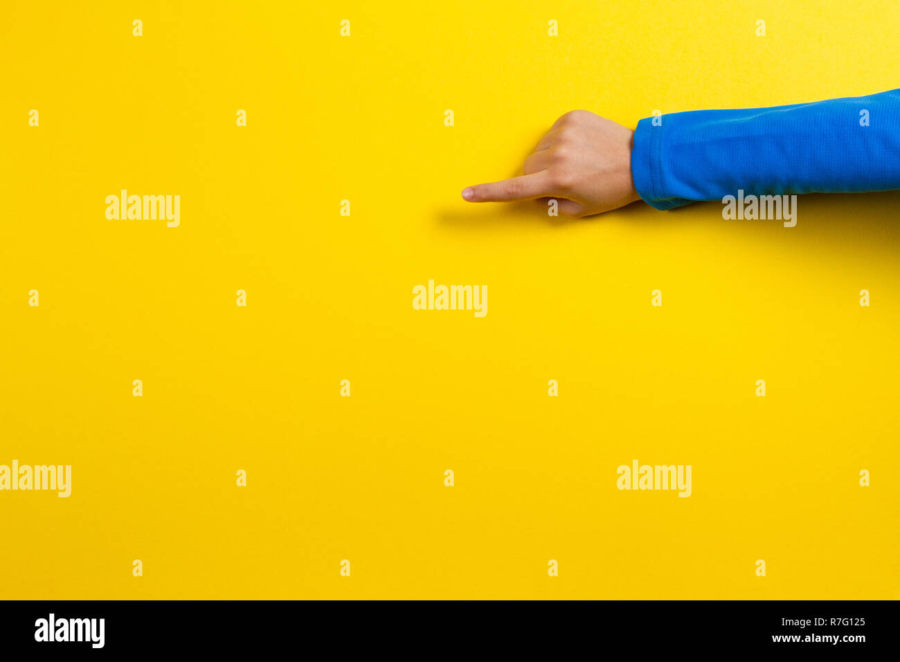 Kid hand pointing or touching something on yellow background Stock ...