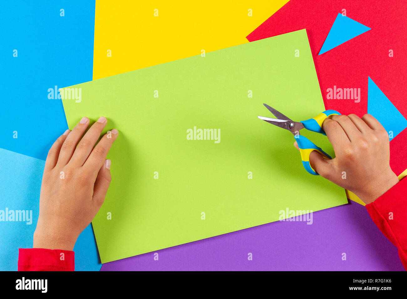 Kid's hands cutting colored paper with scissors Stock Photo - Alamy