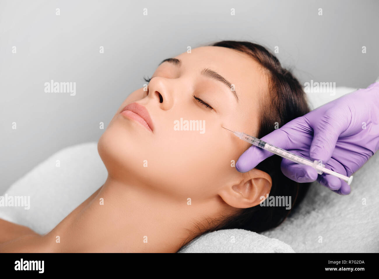 Woman receiving Botulinum Toxin Injection injection into eyes area ...