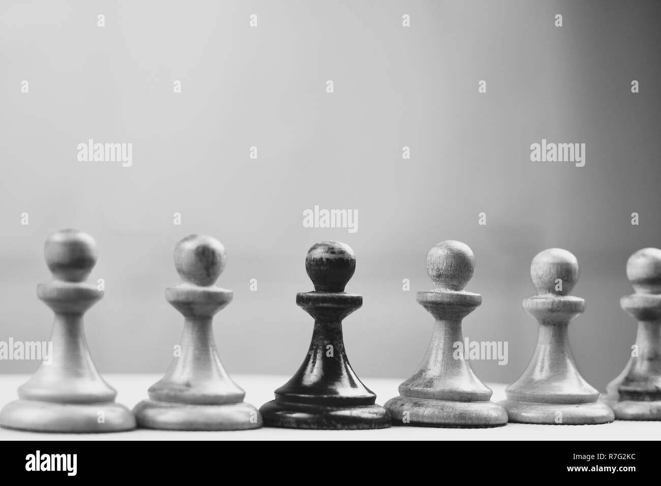 black pawn among white chess pieces Stock Photo - Alamy