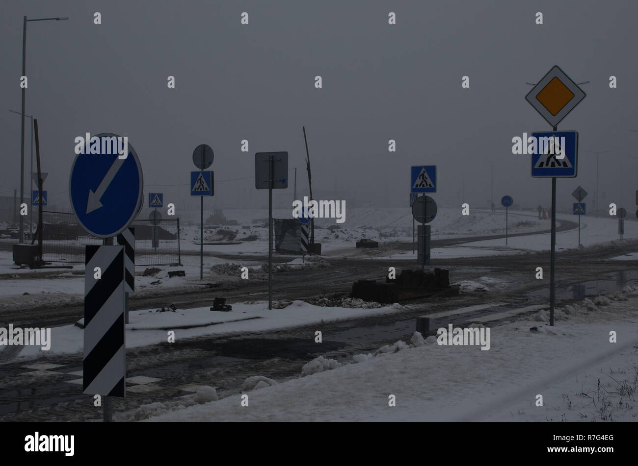 Heavy fog, road works in the city in cloudy snowy weather, repair of a ...