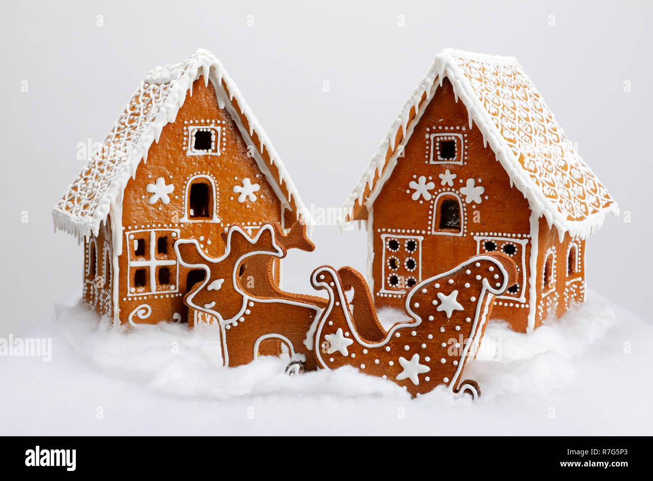 The hand-made eatable gingerbread houses, reindeer and cart with snow ...