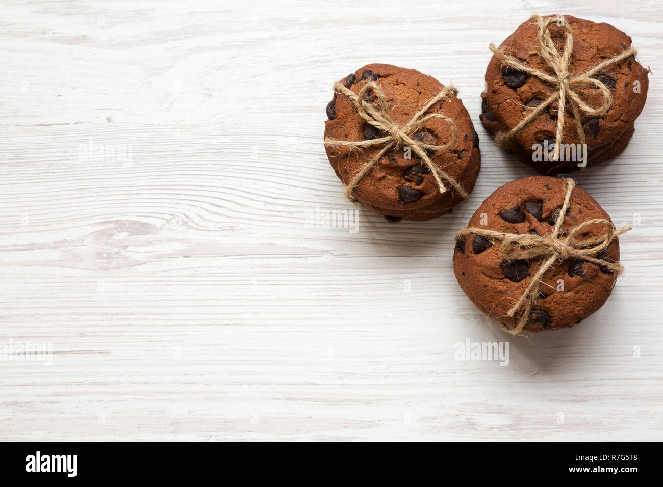 Homemade chocolate chip cookies on a white wooden background, overhead ...