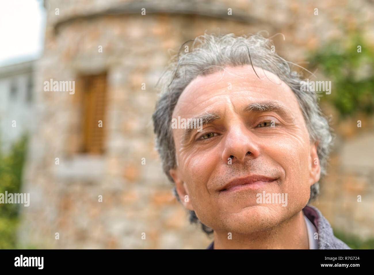 man smiling with brick house in background Stock Photo - Alamy