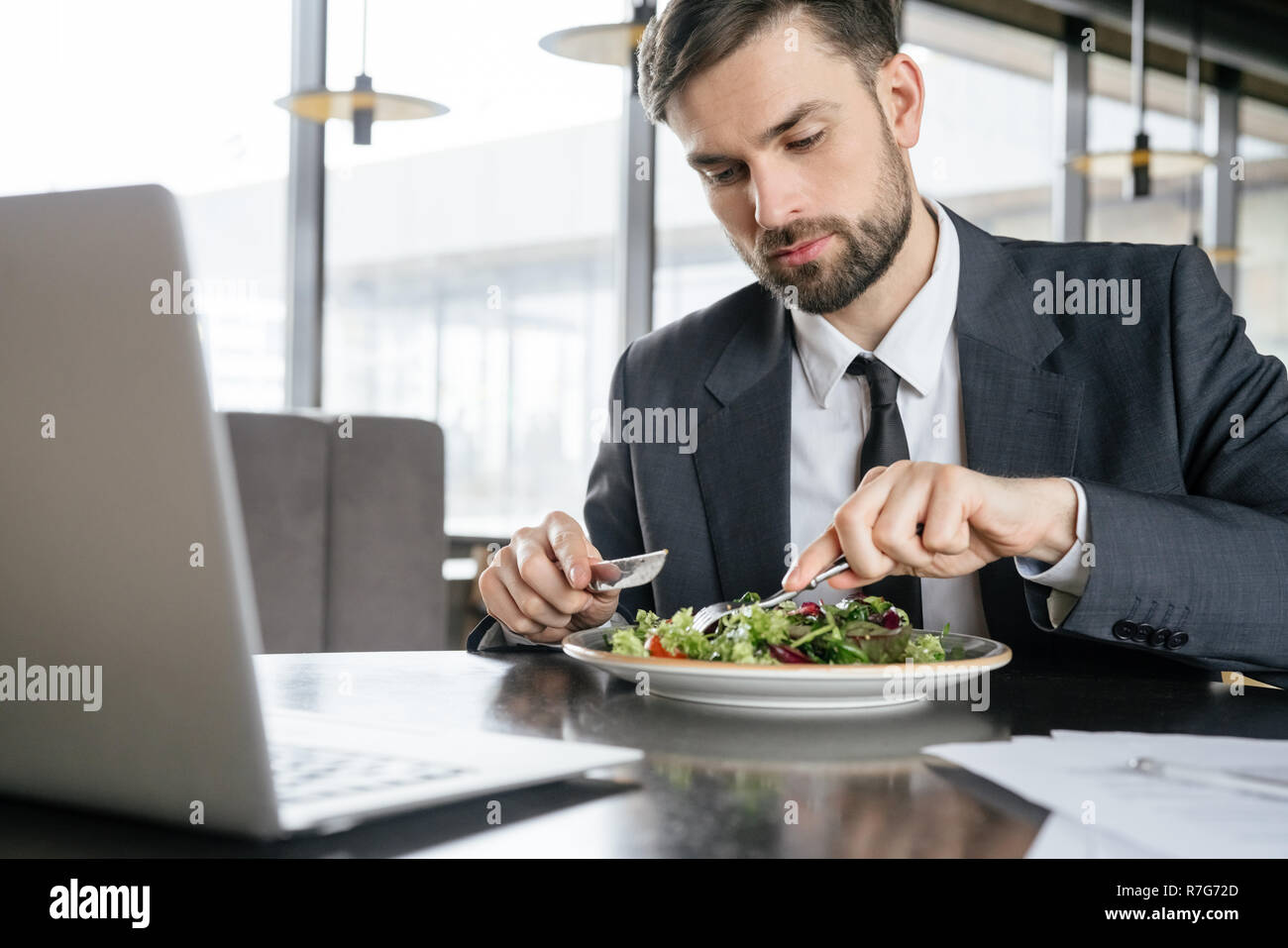Businessperson on business lunch at restaurant sitting eating salad ...