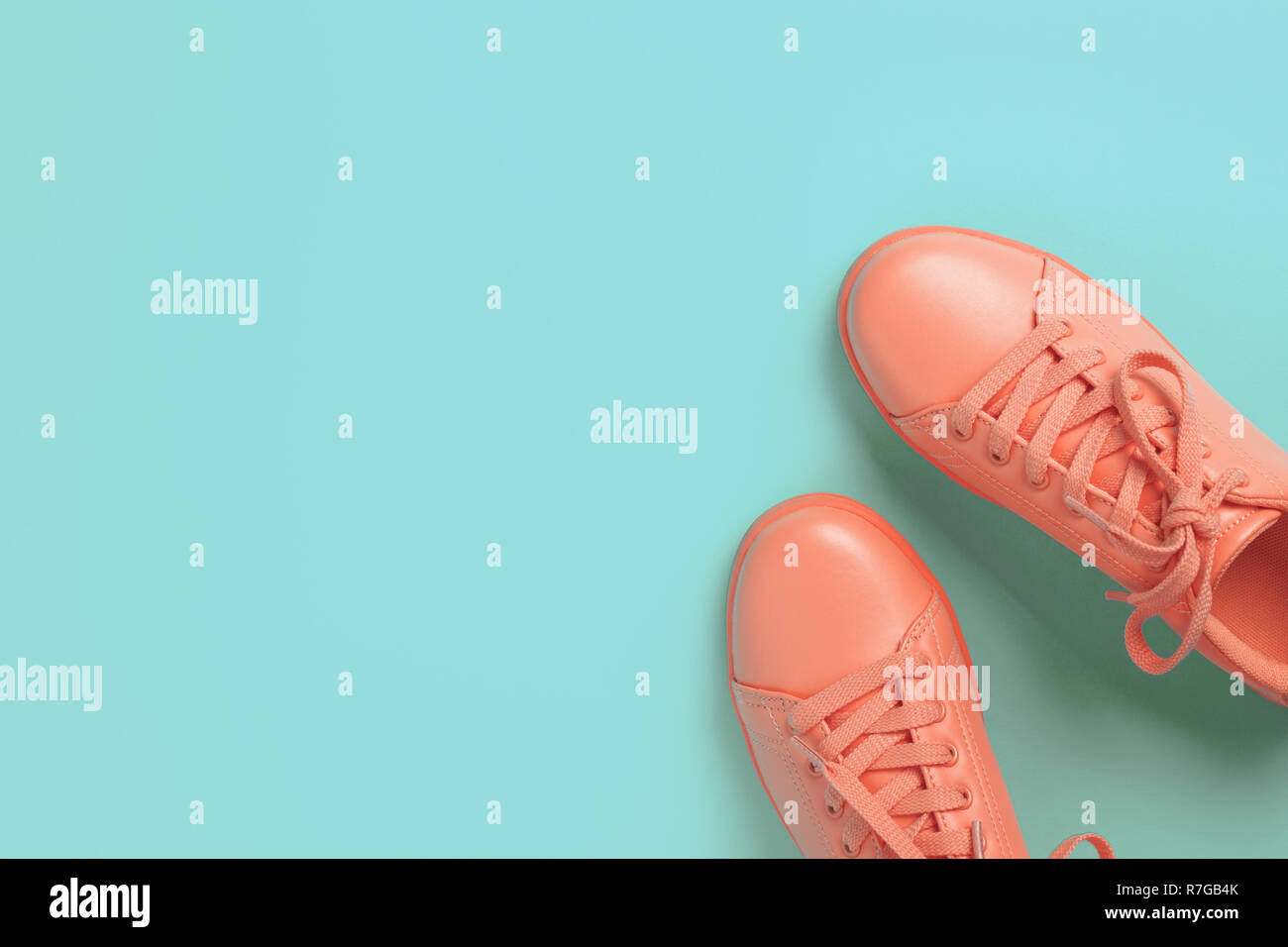 Pair of coral shoes on blue background. Trendy colors of the year 2019 ...