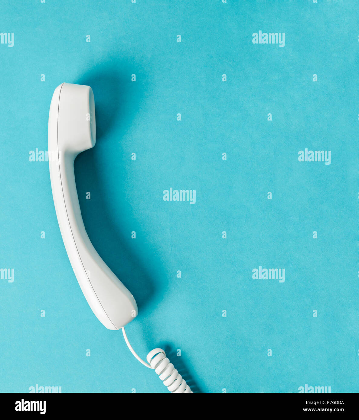 White office desk phone on blue background with free space for your ...