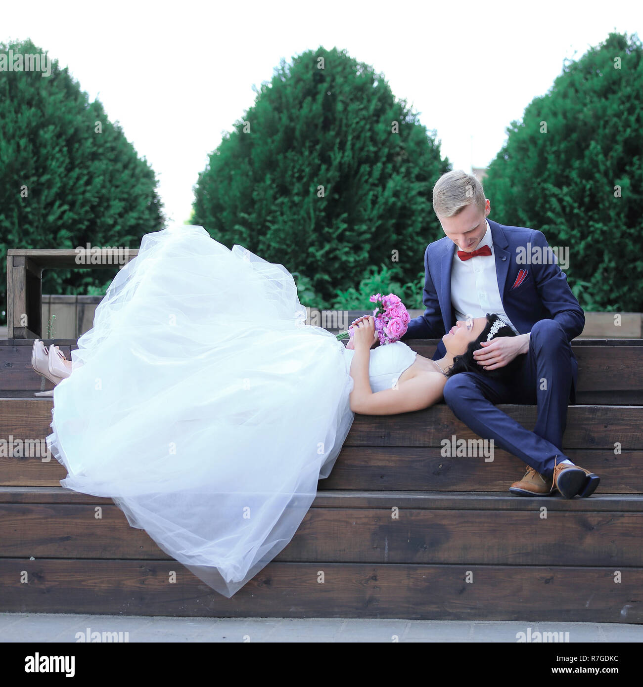 bride and groom resting on a wooden podium Stock Photo - Alamy