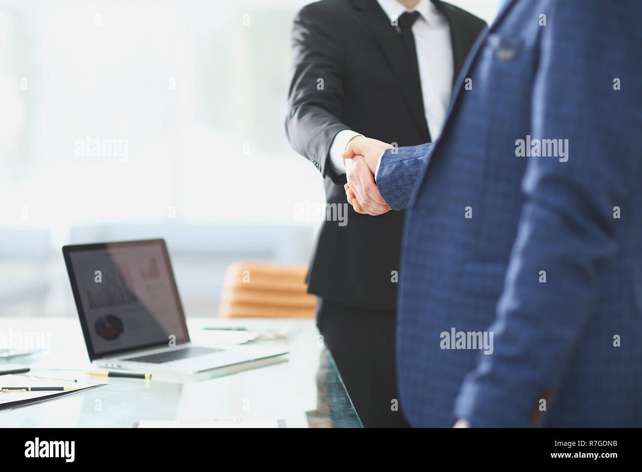 handshake business partners standing next to the Desk Stock Photo - Alamy