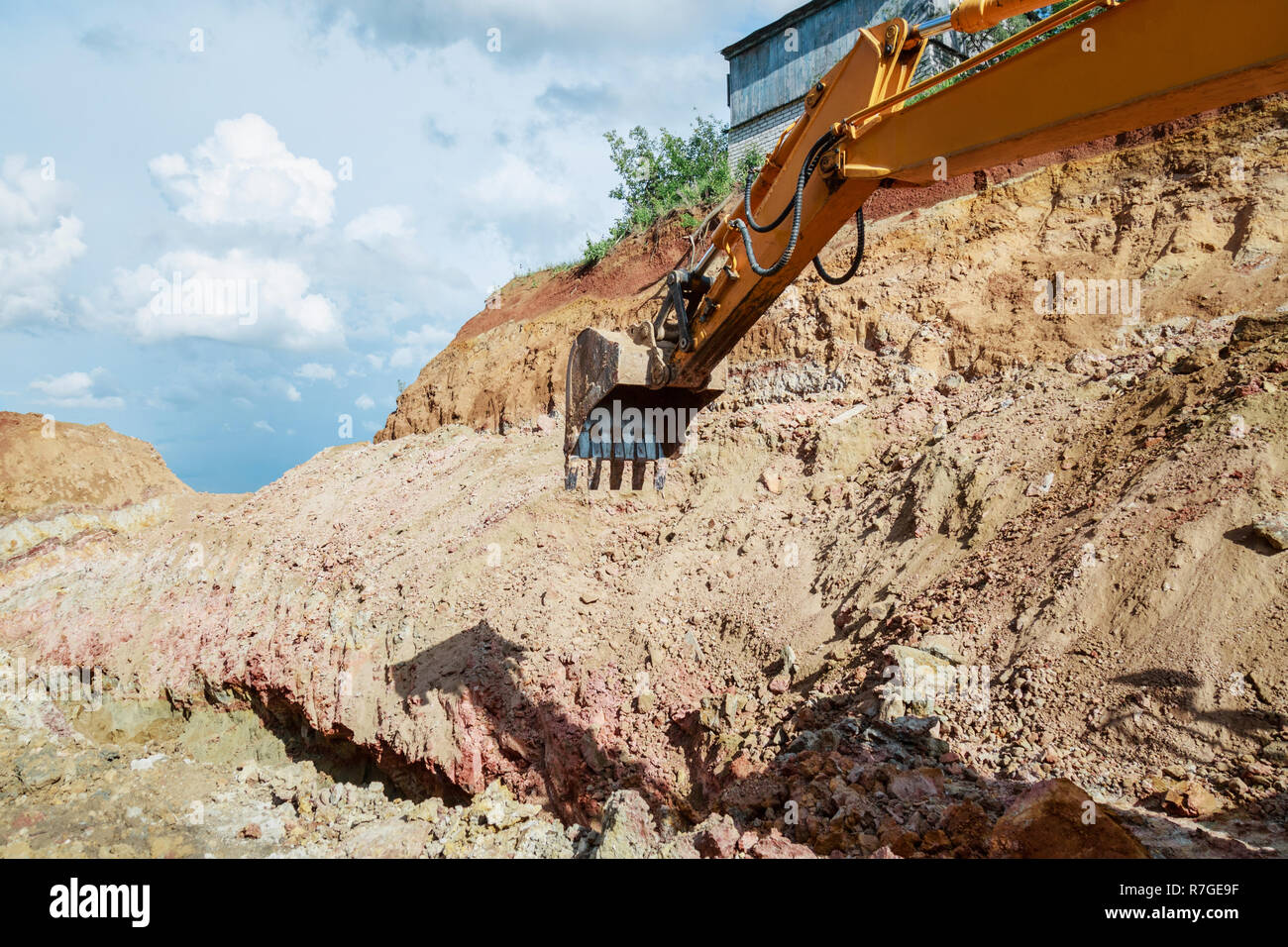 Excavator digging a hole. Work on the construction site Stock Photo - Alamy