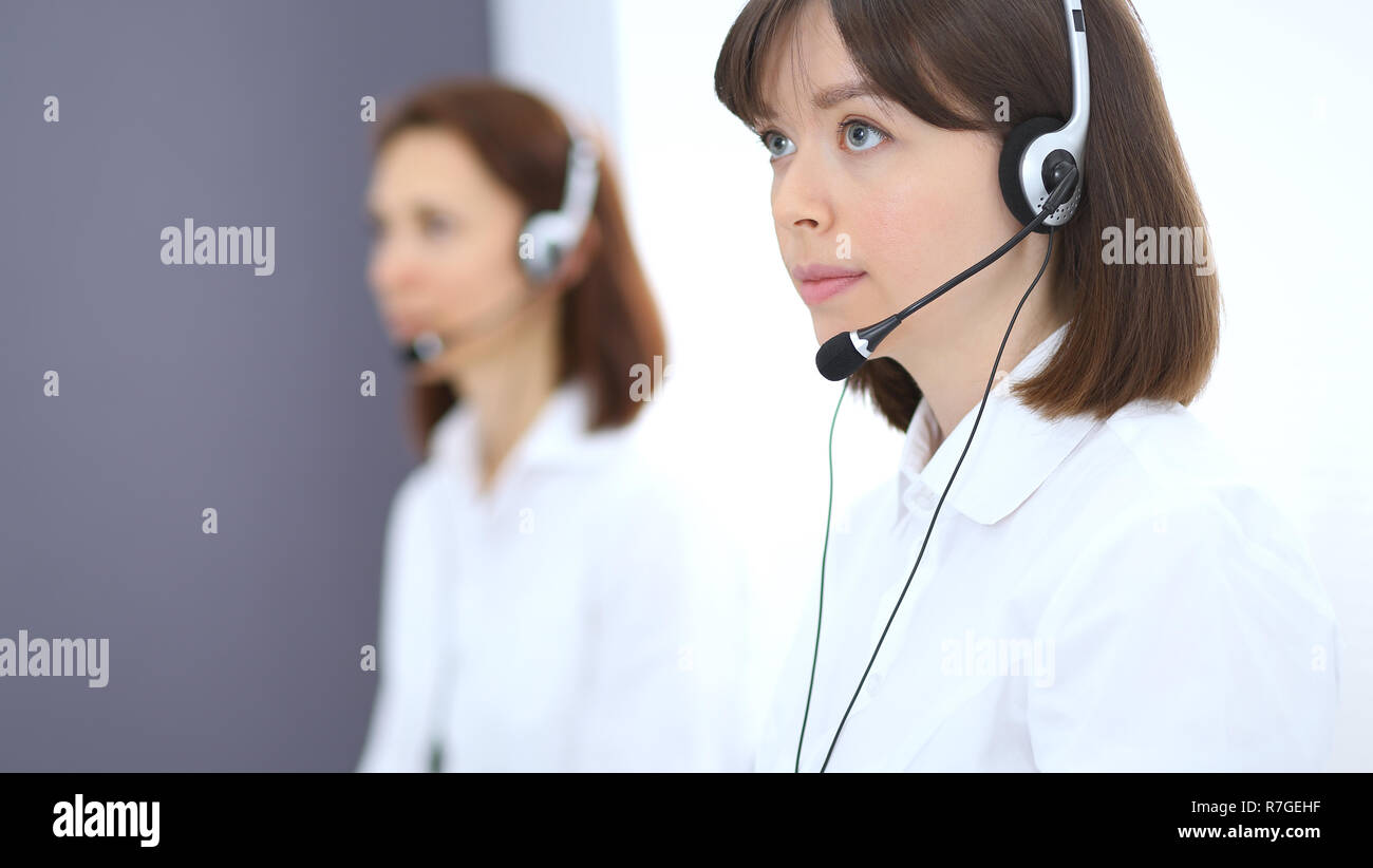 Call center. Group of operators at work. Focus on young brunette woman. Business concept Stock ...