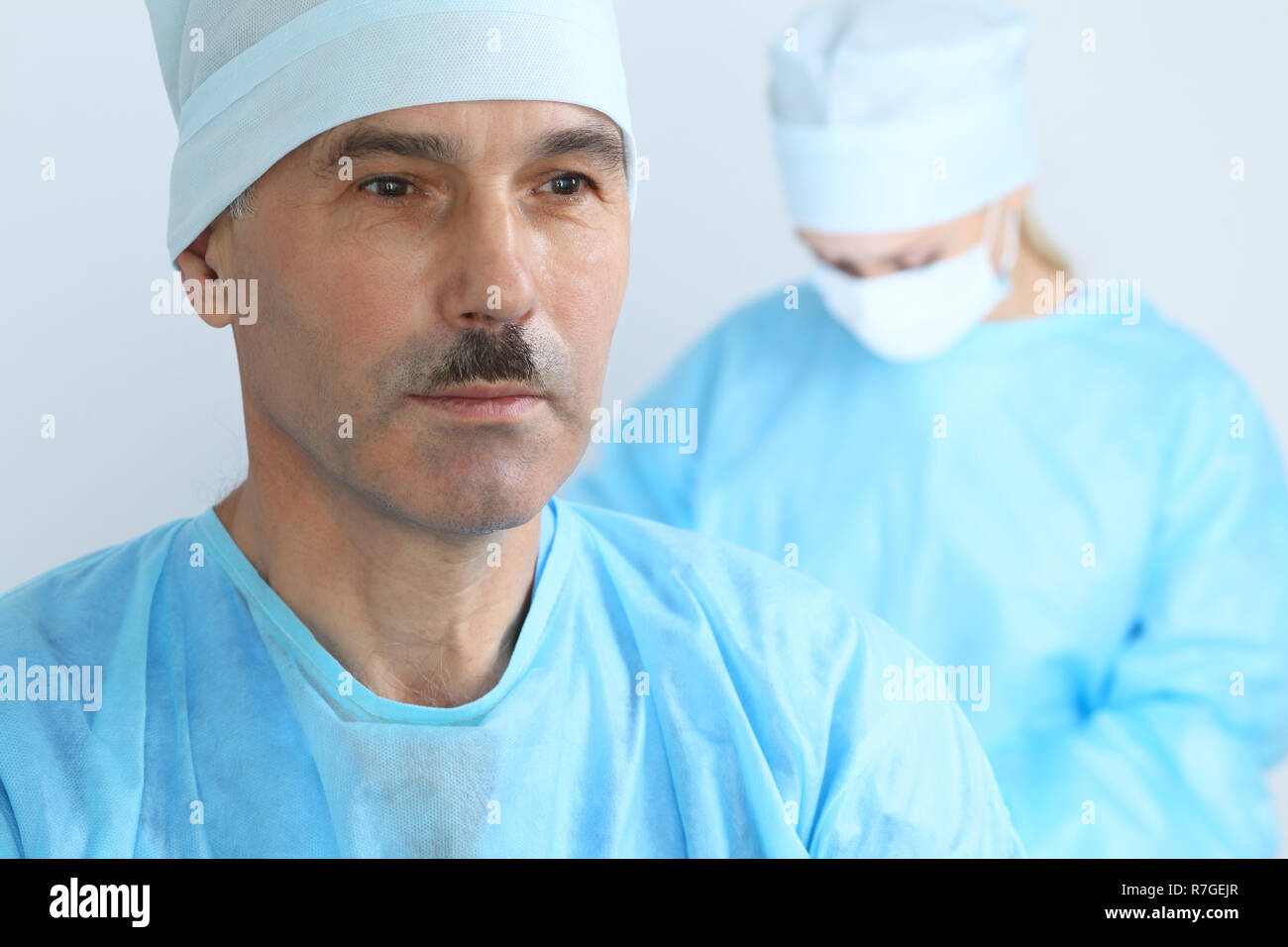 Boss surgeon is examining the operation while medical team are busy of ...