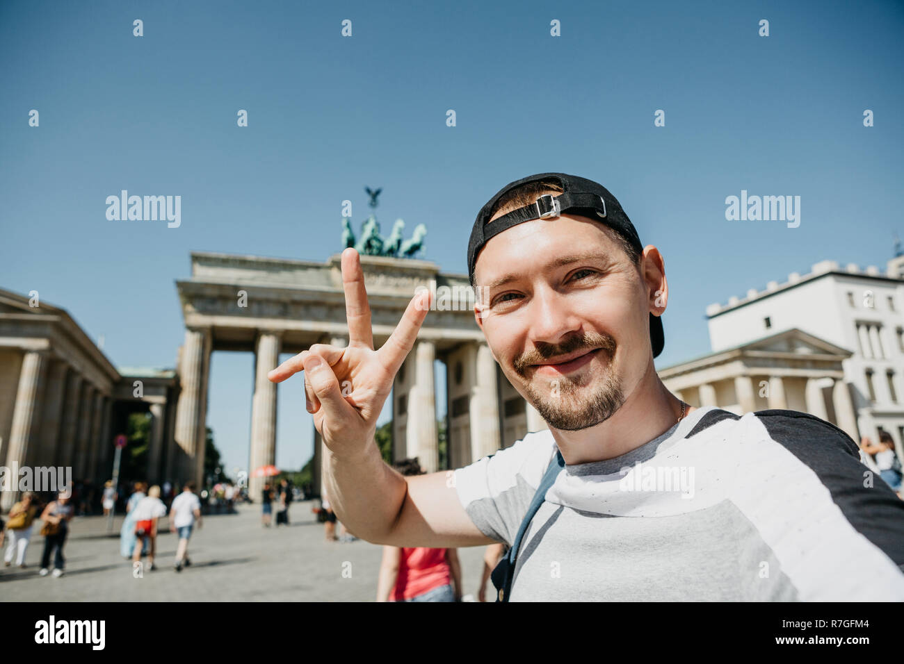 Tourist guy makes selfie on the background of the Brandenburg Gate in ...