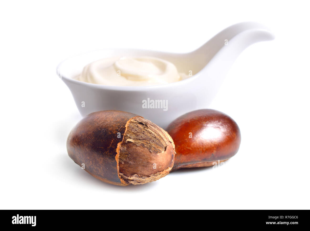 Shea nuts with butter or cream in the bowl. Isolated on white ...