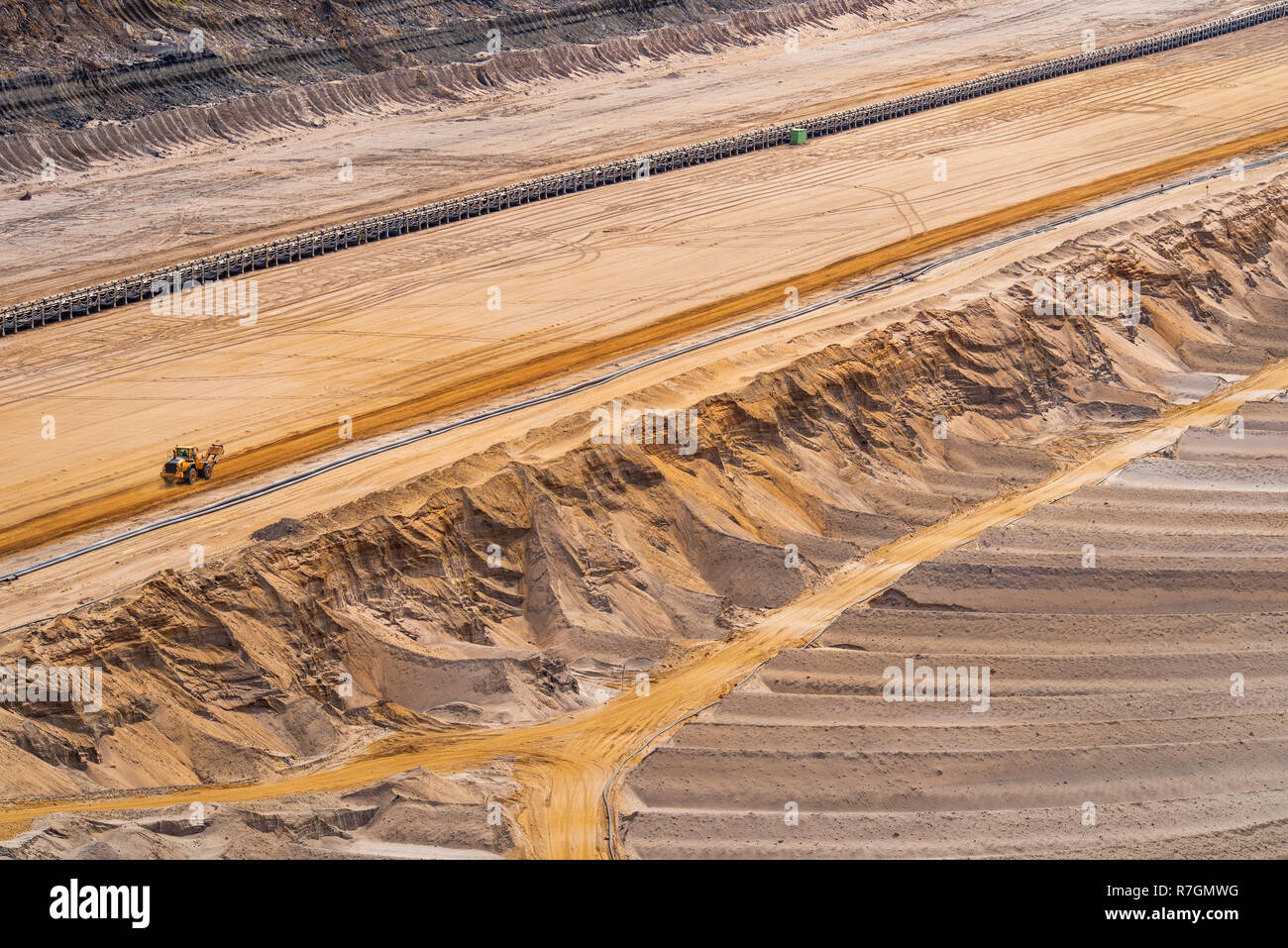 View into a lignite mine with conveyor belts and driveways in the sand ...