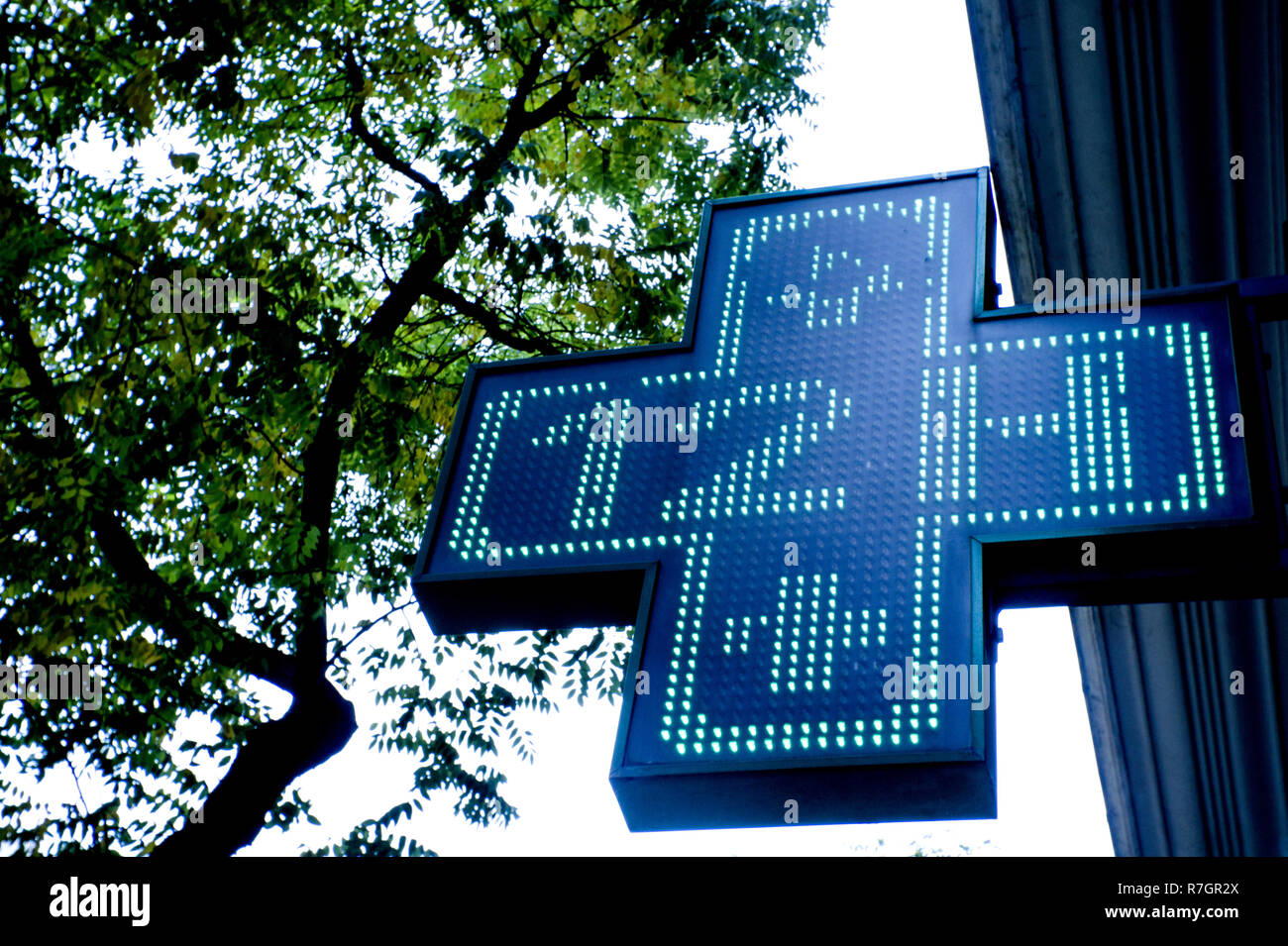 Pharmacy sign indicating open twelve hours. Green cross Stock Photo - Alamy