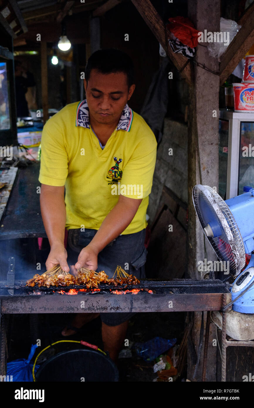 Chicken satay cooking on a tradition open coal barbecue on Bali ...