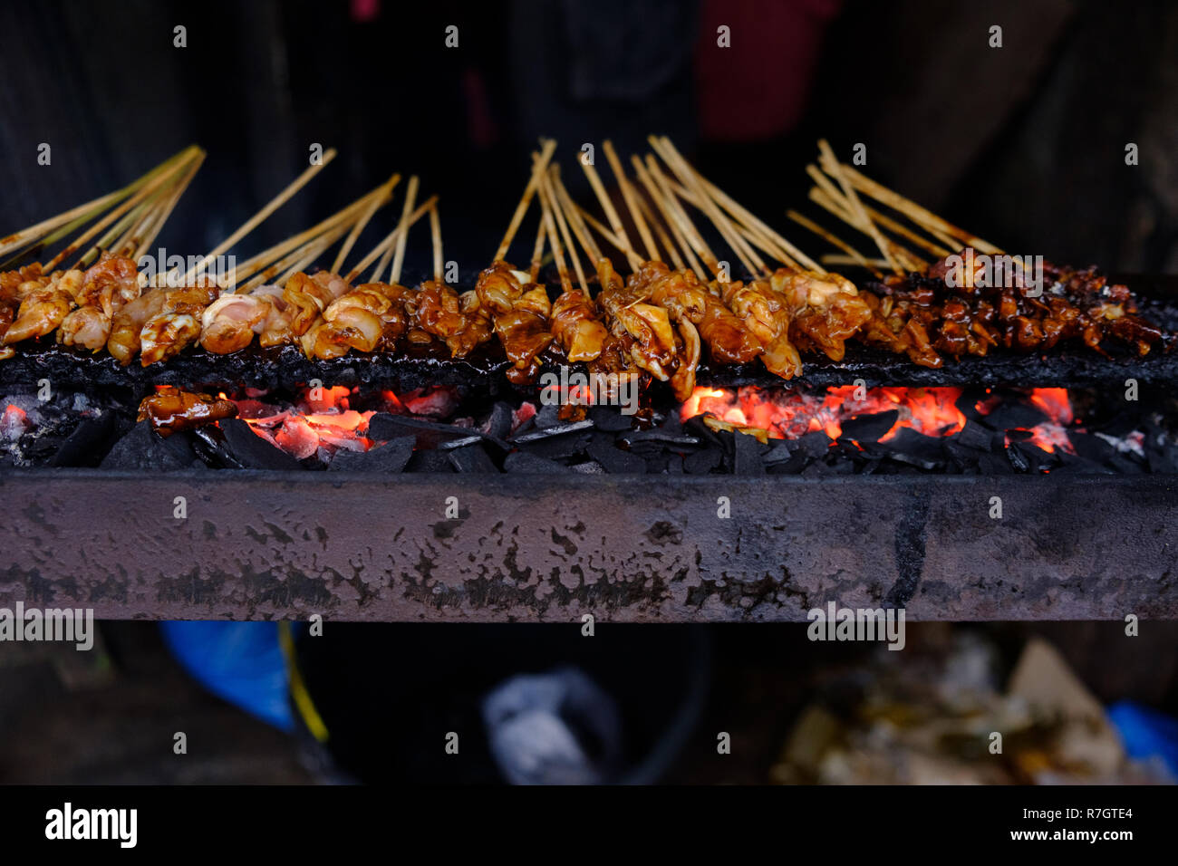 Chicken satay cooking on a tradition open coal barbecue on Bali ...