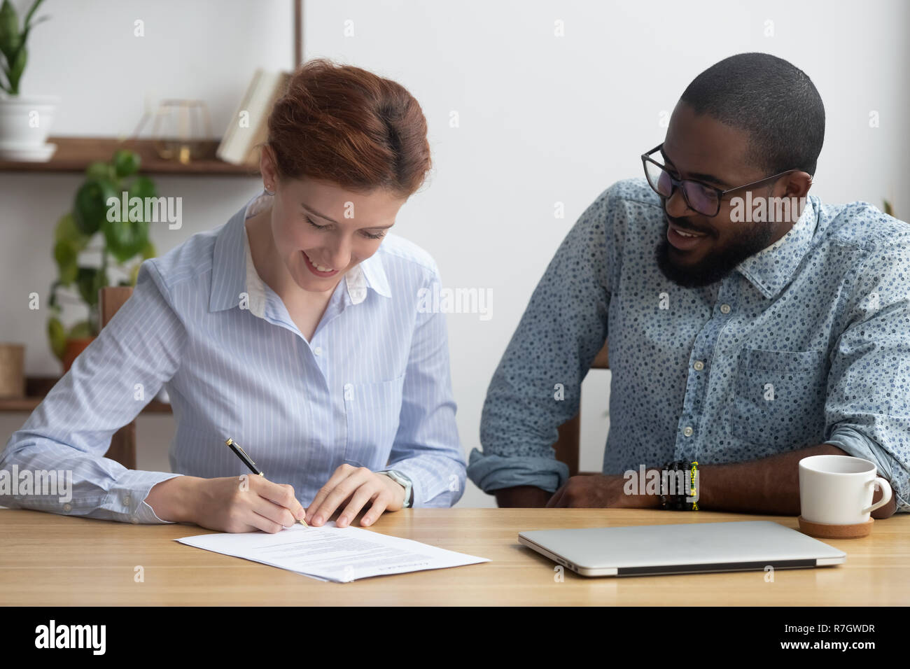 Female signing job contract sitting together with company owner Stock ...
