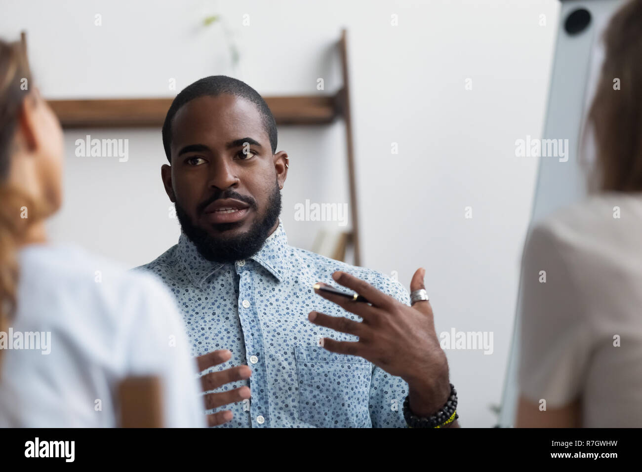 Business coach teaching young company workers telling about busi Stock ...