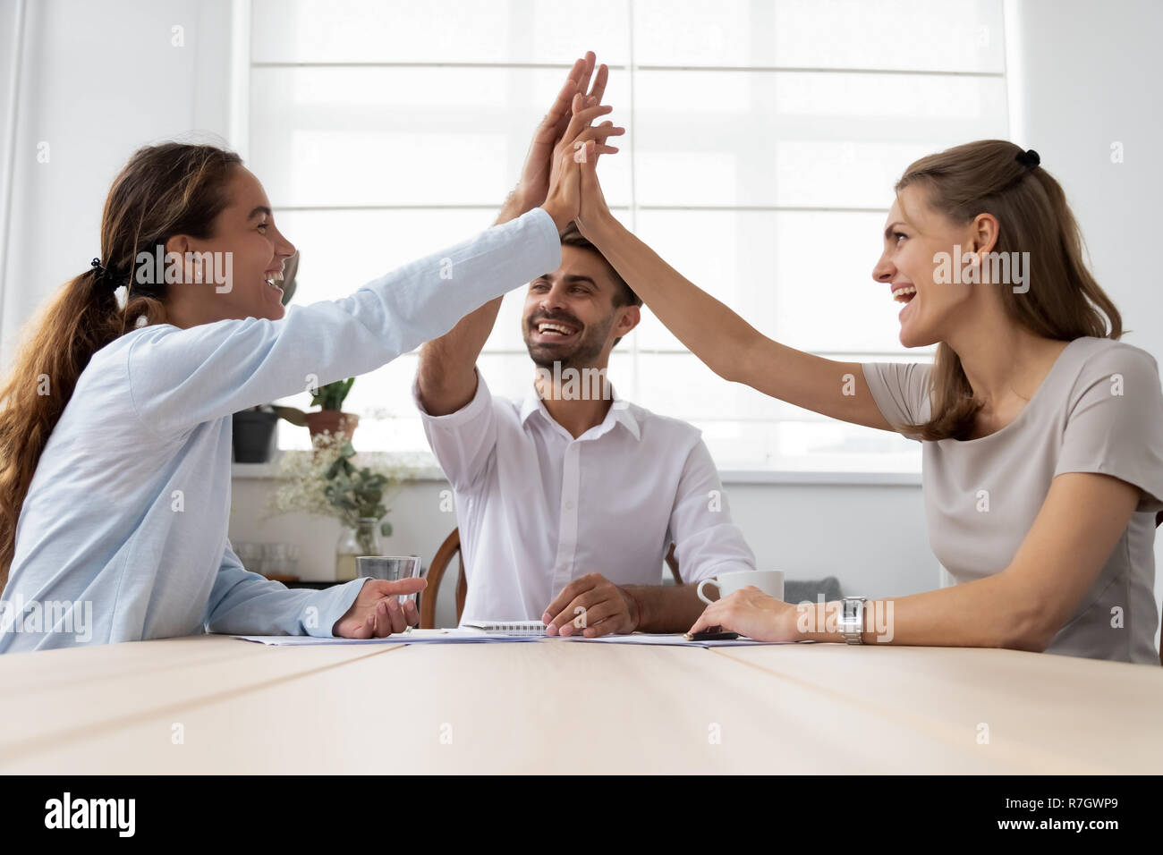 Happy diverse coworkers celebrating success in work giving high Stock ...