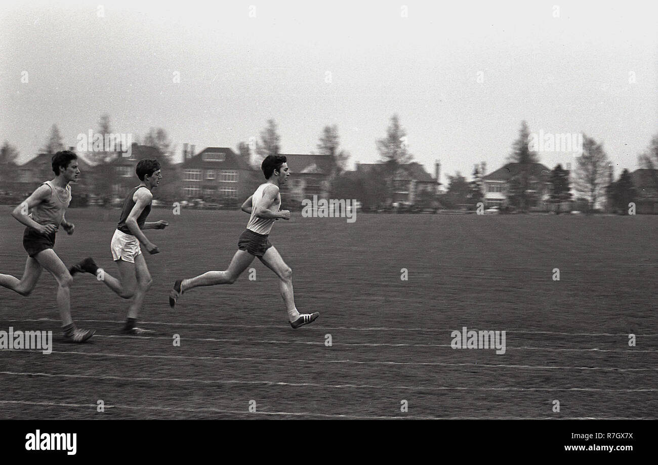 1960s, track and field, young male athletes running in a race outside ...