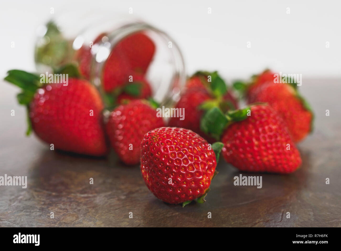 Scattered strawberries on a kitchen table, white background Stock Photo ...