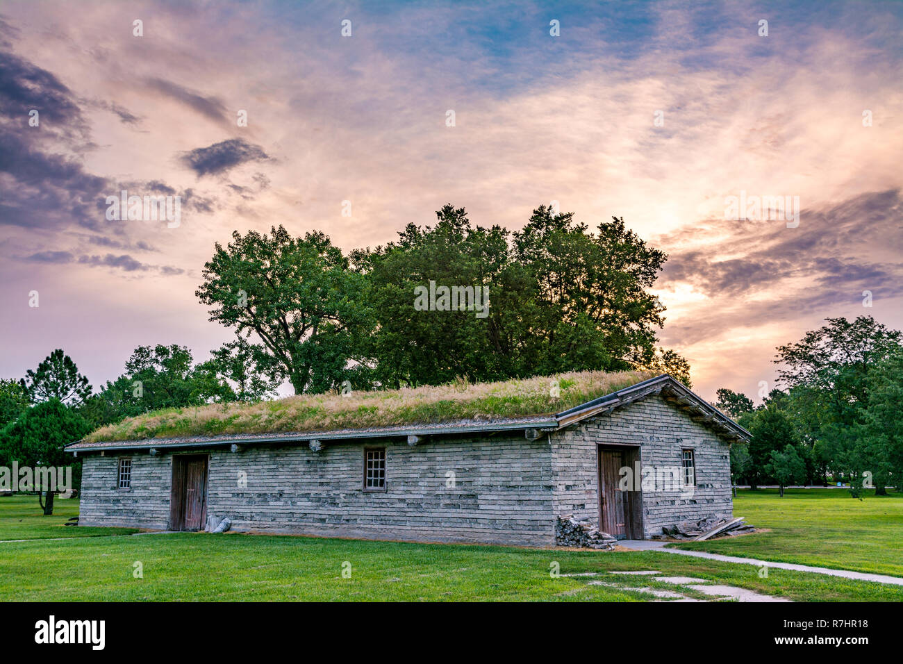 Long building made from mud bricks with a sod roof and sunrise Stock ...