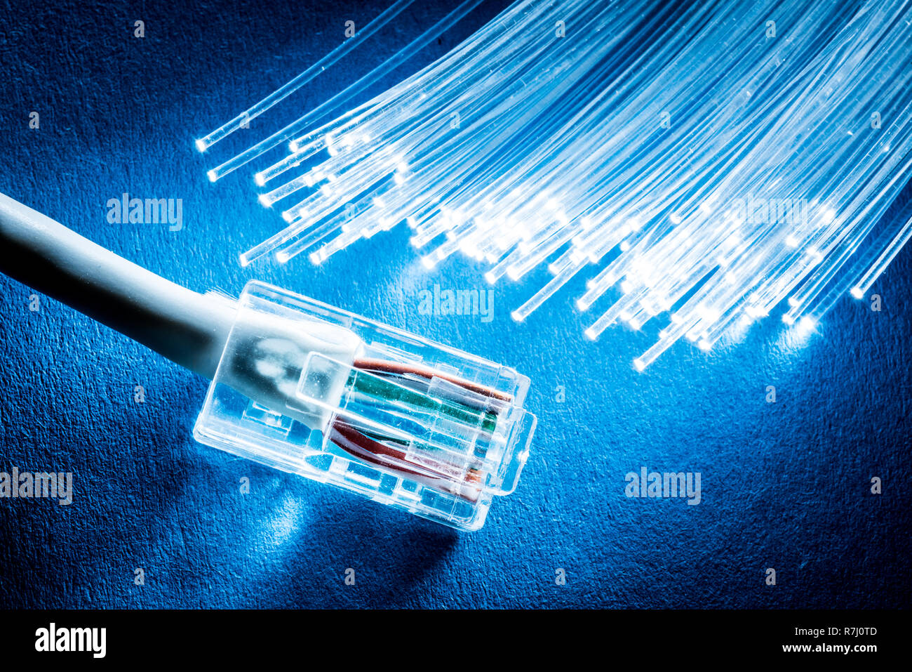 Network cable and optical fibers with lights on blue background Stock ...