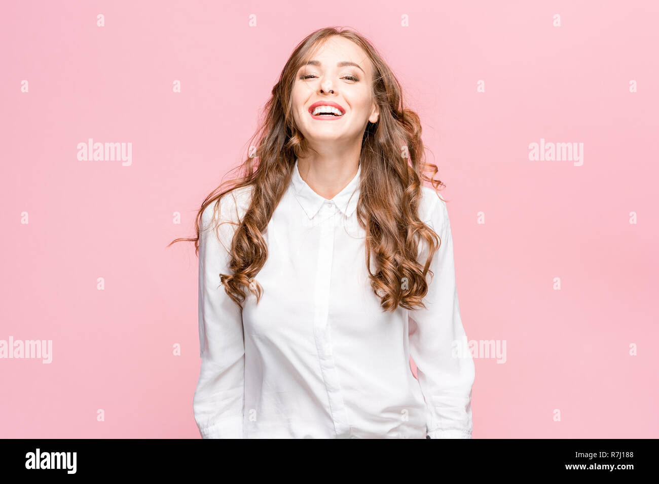 The young woman's portrait with happy emotions on pink background Stock ...