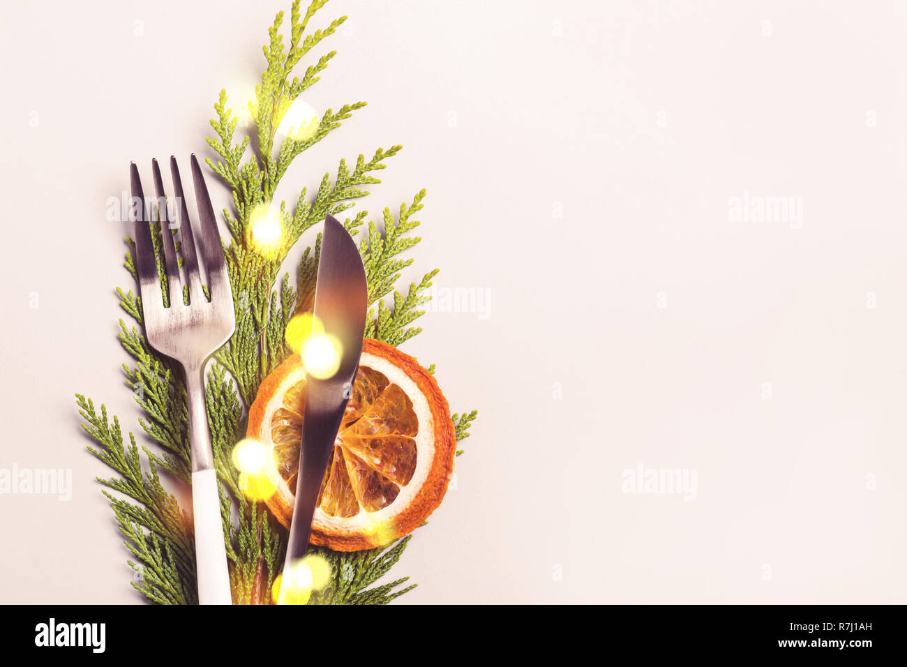 Christmas table setting concept. Fork and knife decorated with thuja ...