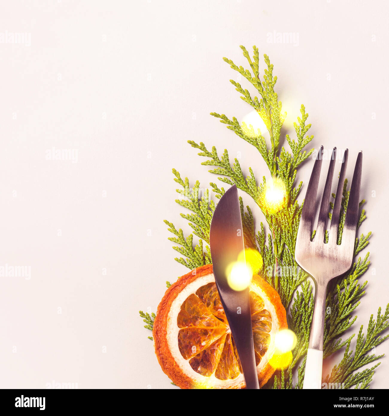 Christmas table setting concept. Fork and knife decorated with thuja ...