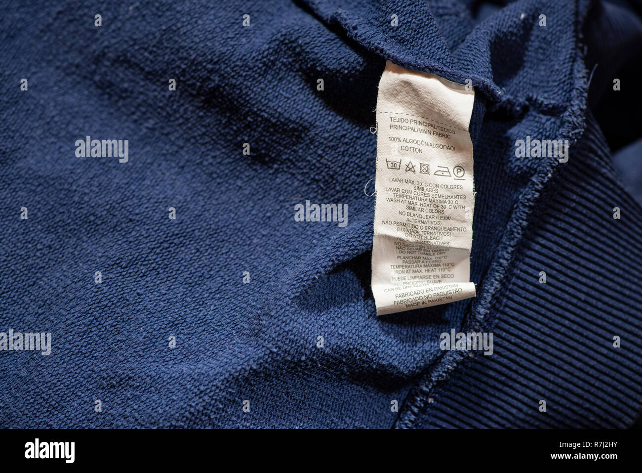 Label inside on cotton shirt. Copy space on blue background of fabric ...
