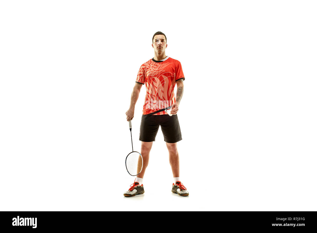 Young man badminton player standing over white studio background. Fit ...