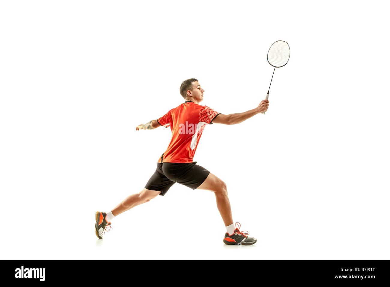 Young man playing badminton over white studio background. Fit male ...