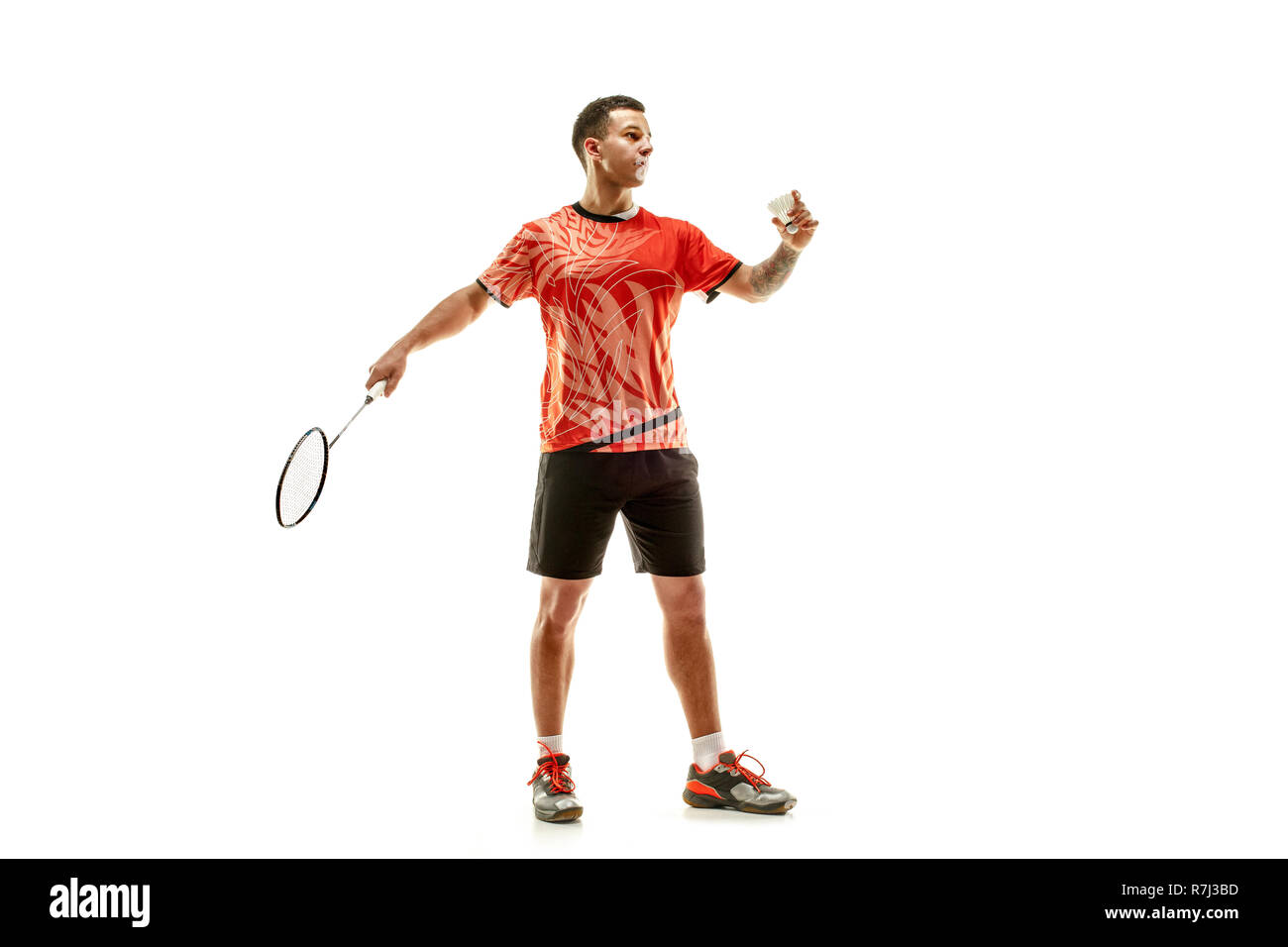 Young man playing badminton over white studio background. Fit male ...