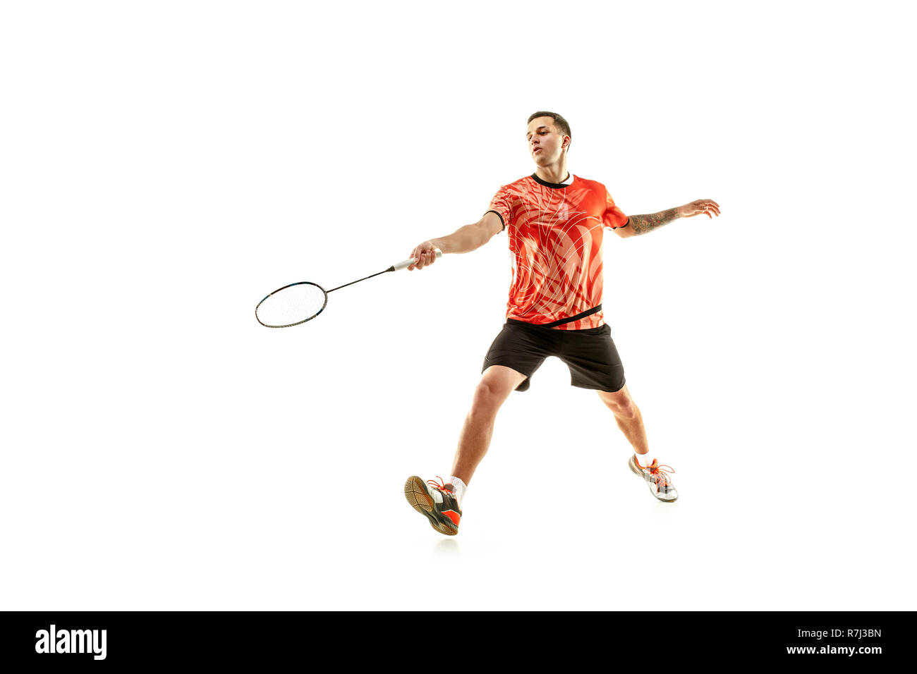 Young man playing badminton over white studio background. Fit male ...