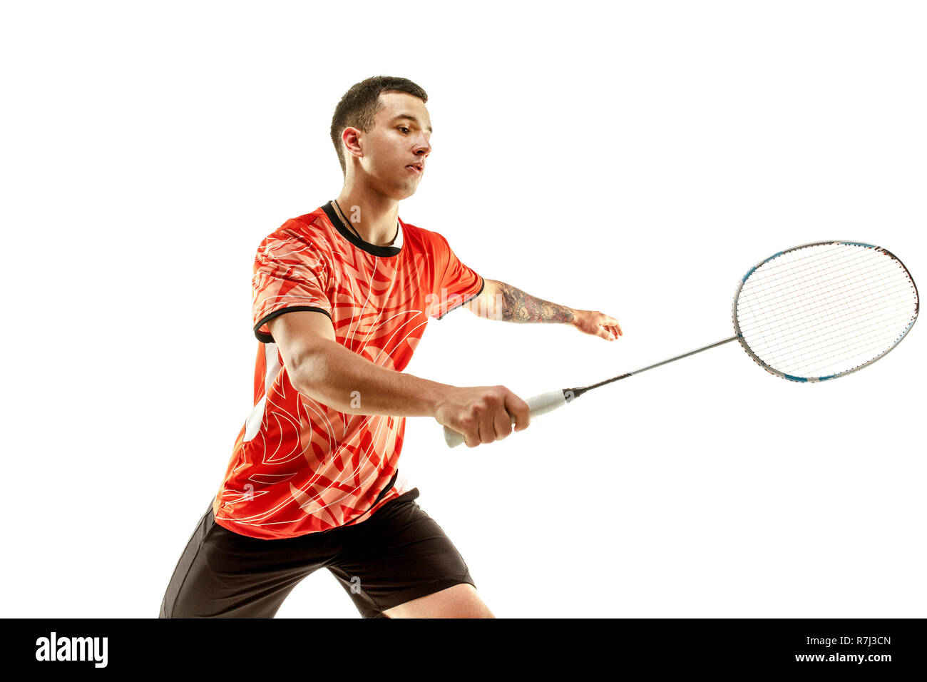 Young man playing badminton over white studio background. Fit male ...