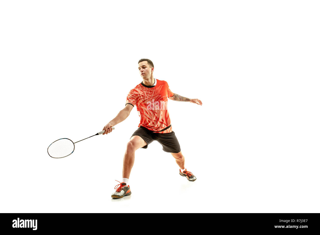 Young man playing badminton over white studio background. Fit male ...