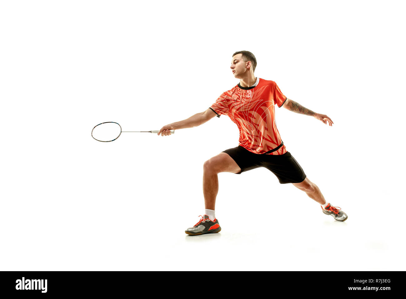 Young man playing badminton over white studio background. Fit male ...