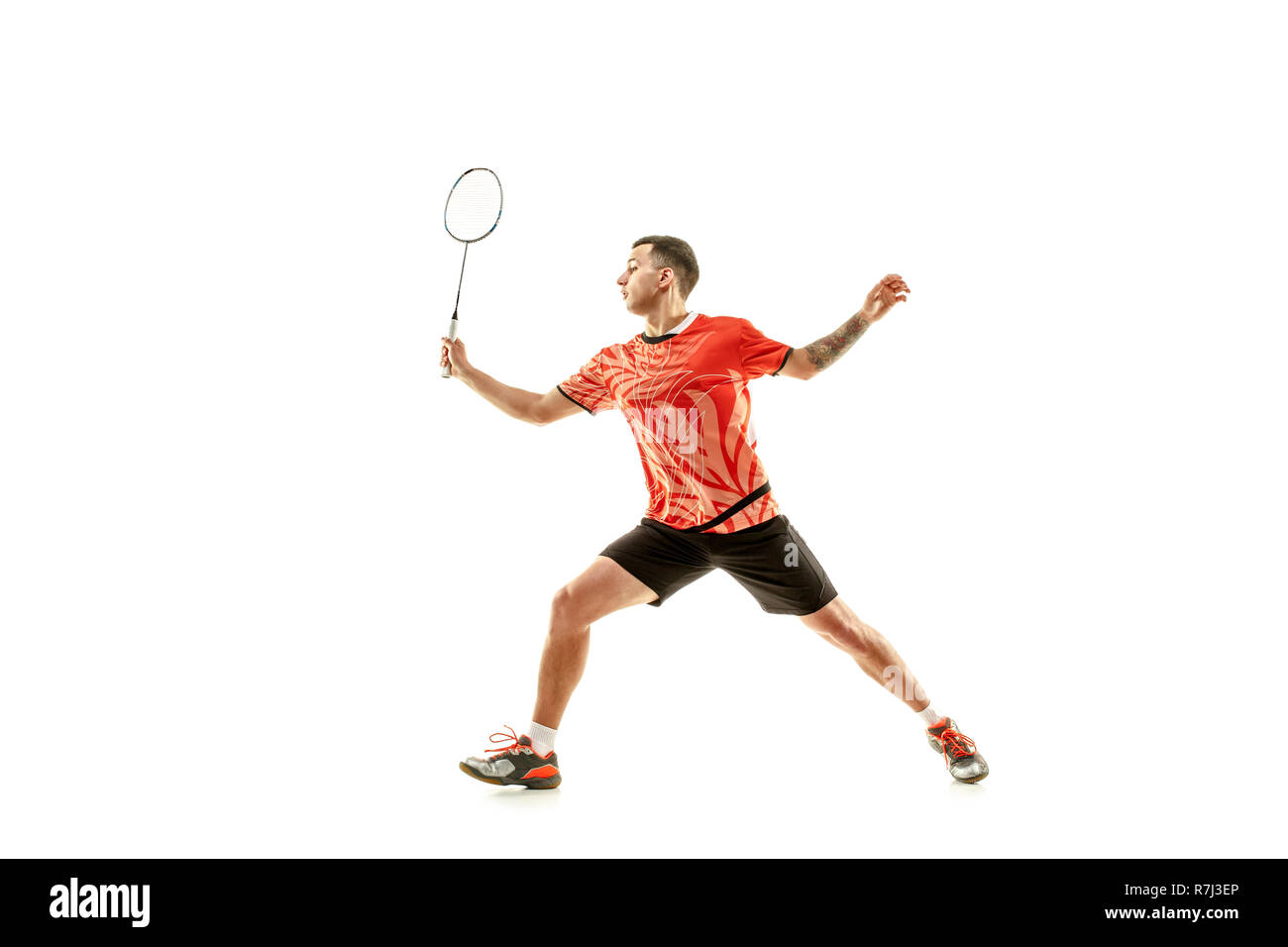 Young man playing badminton over white studio background. Fit male ...