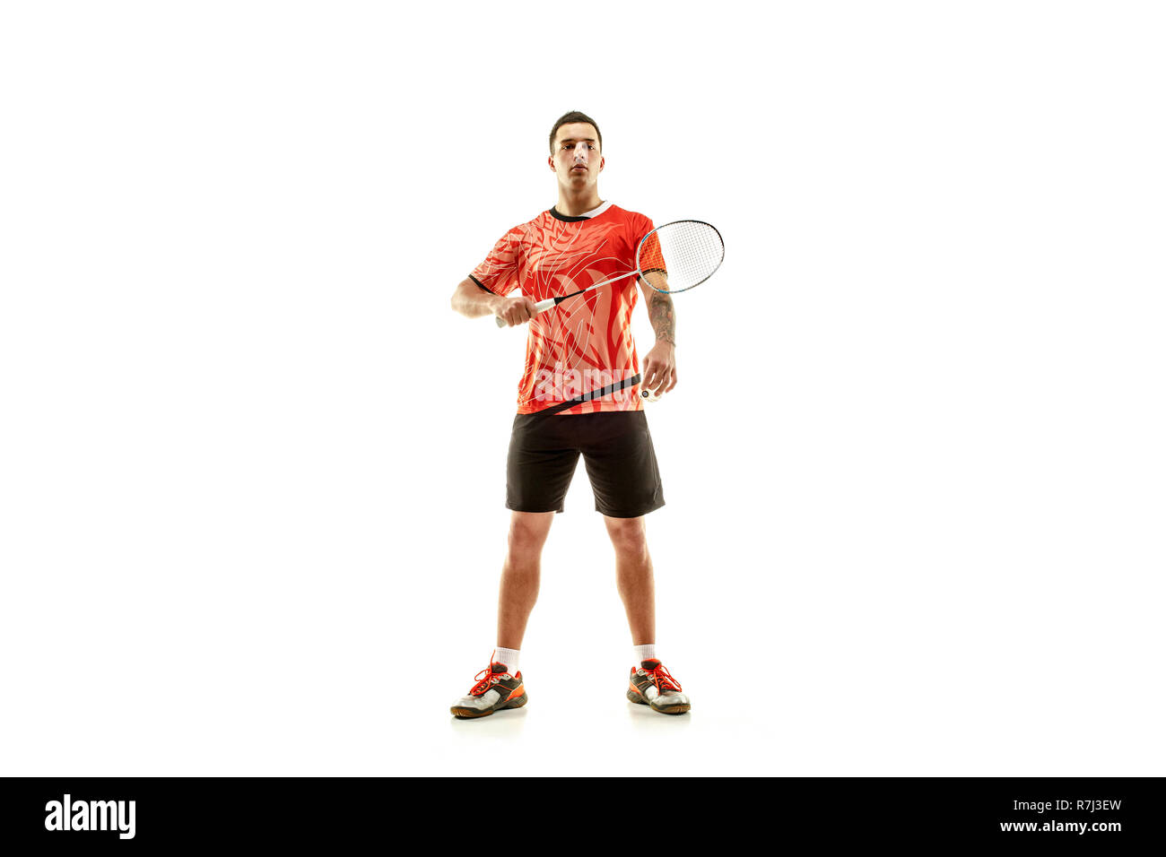 Young man badminton player standing over white studio background. Fit ...