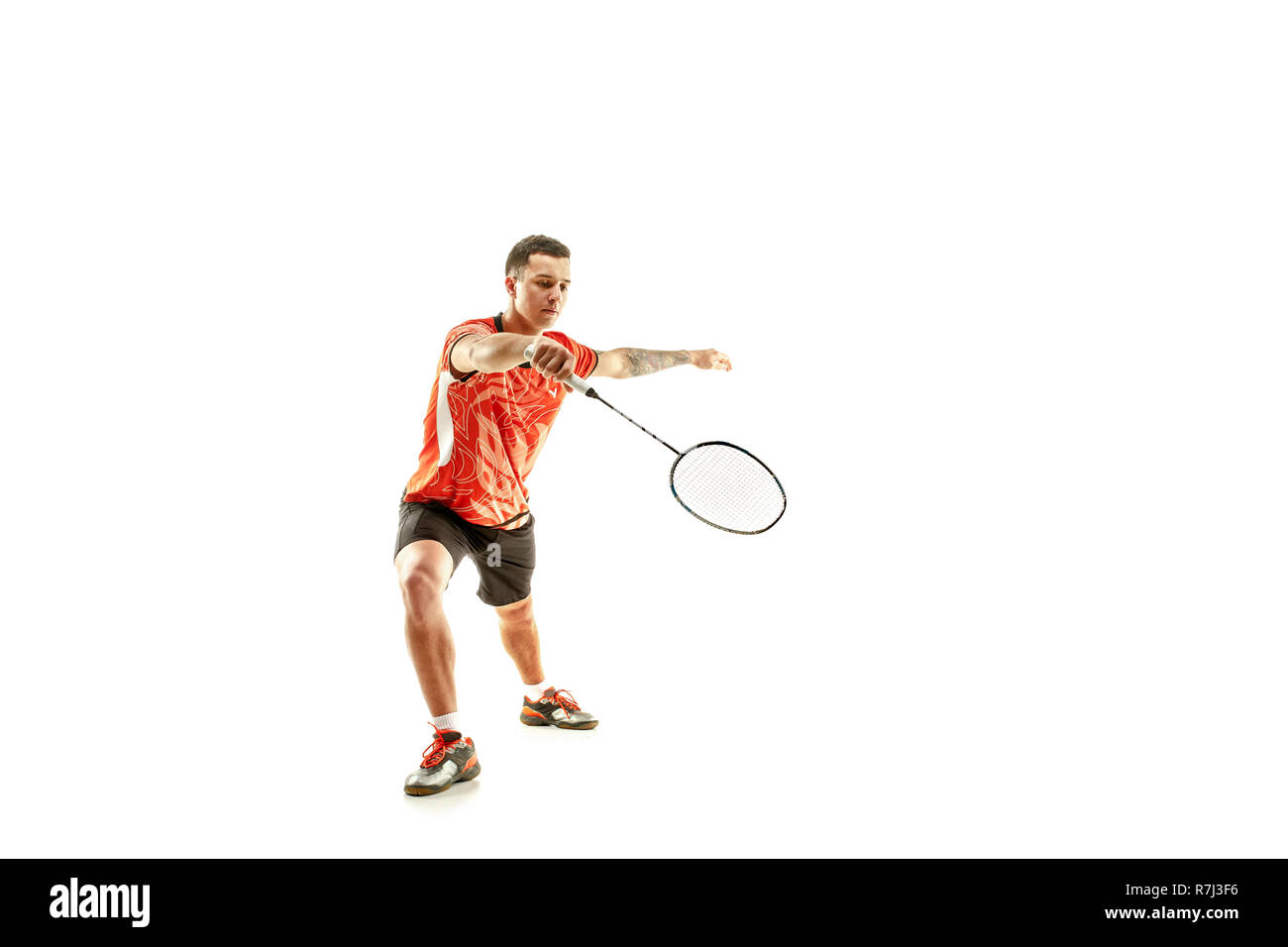 Young man playing badminton over white studio background. Fit male ...