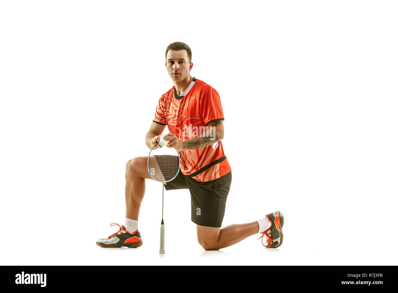 Young man playing badminton over white studio background. Fit male ...