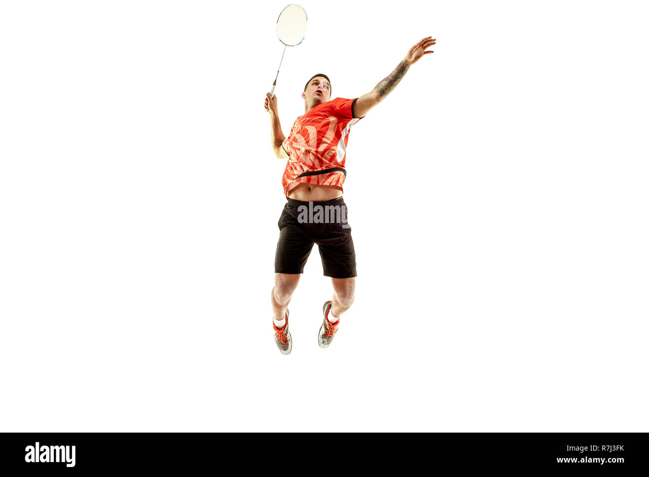 Young man playing badminton over white studio background. Fit male ...