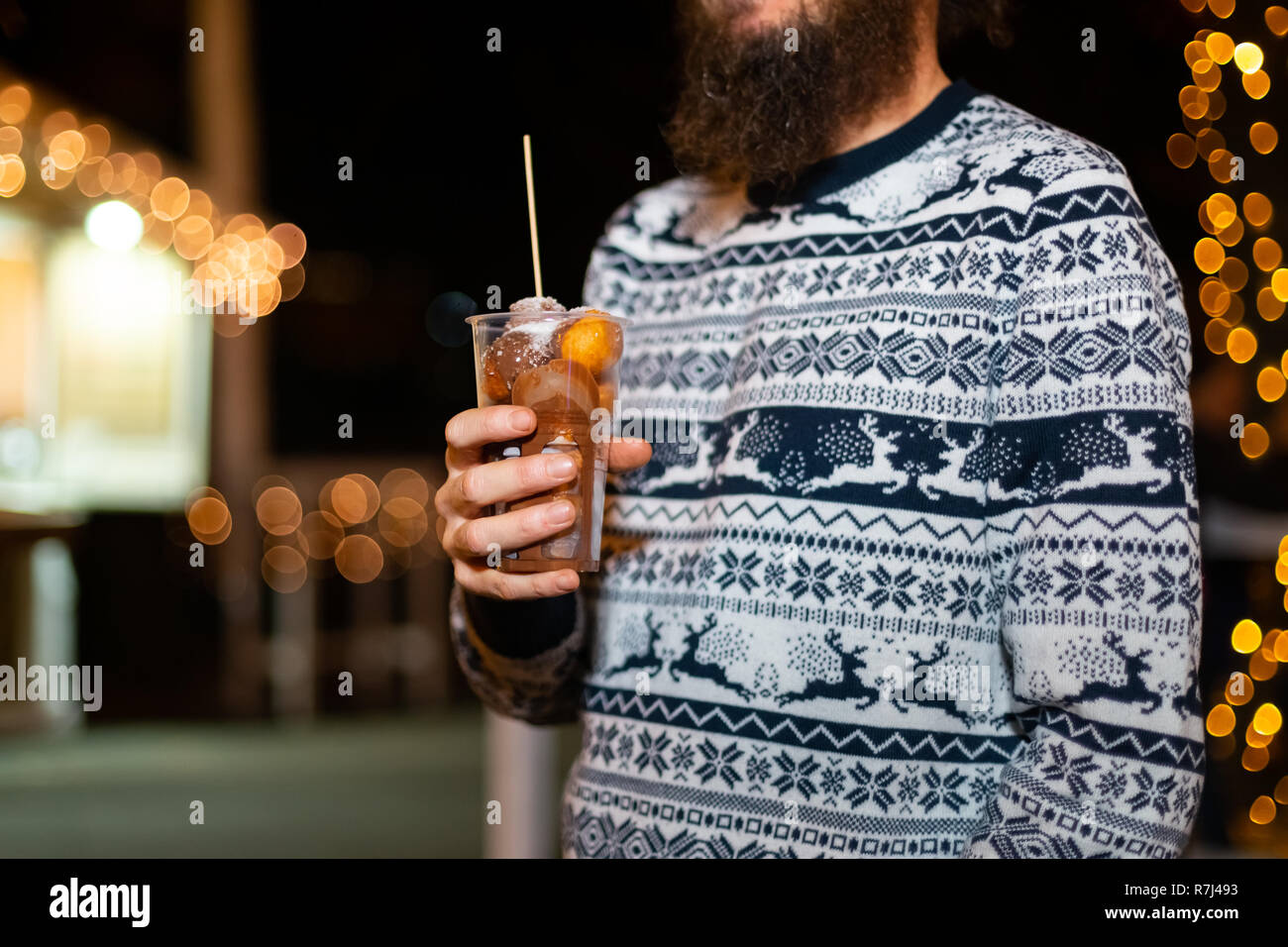 Man holding traditional fritula at Christmas market. Zagreb, Croatia ...