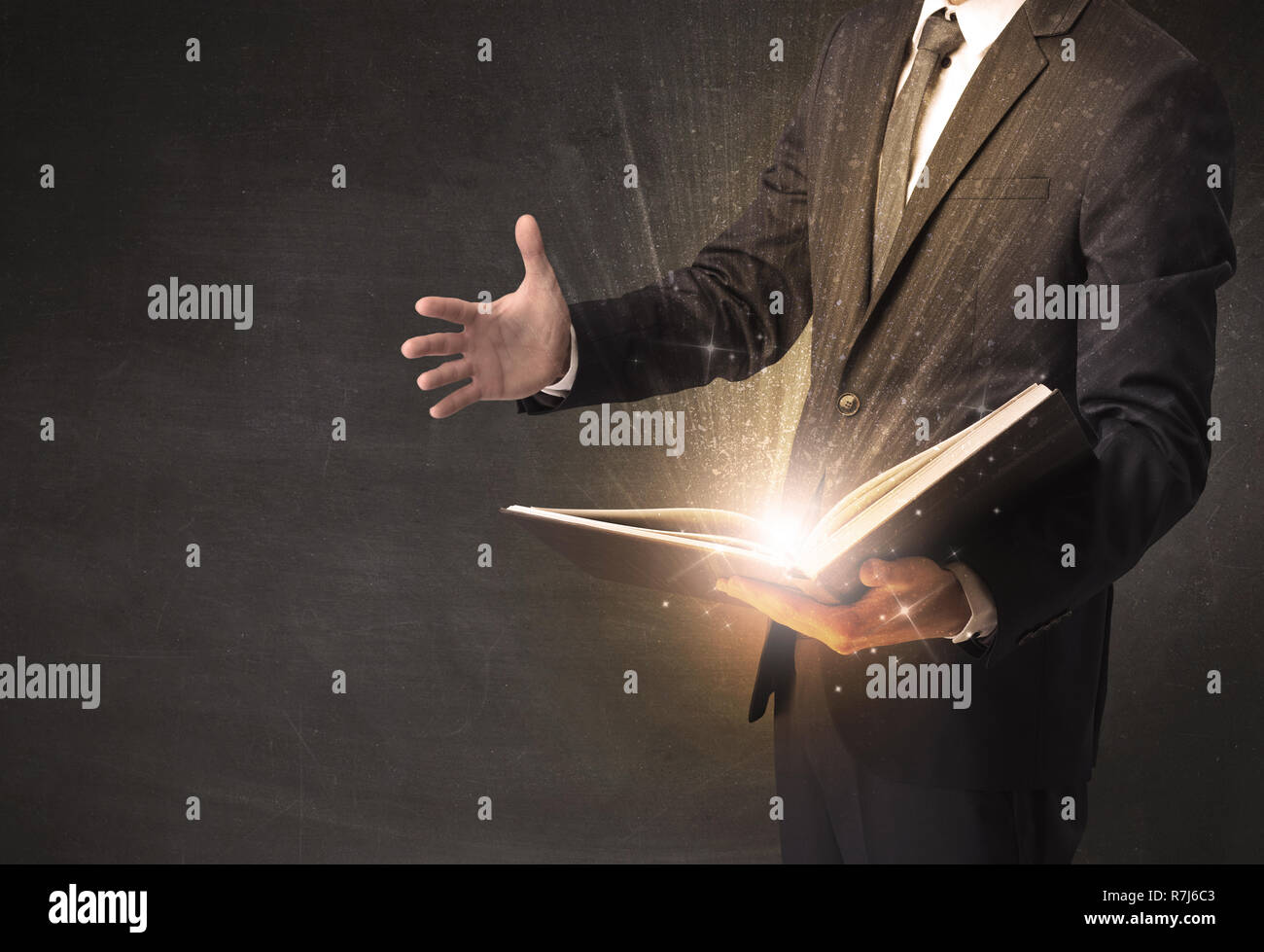 Man holding and reading a shiny book Stock Photo - Alamy