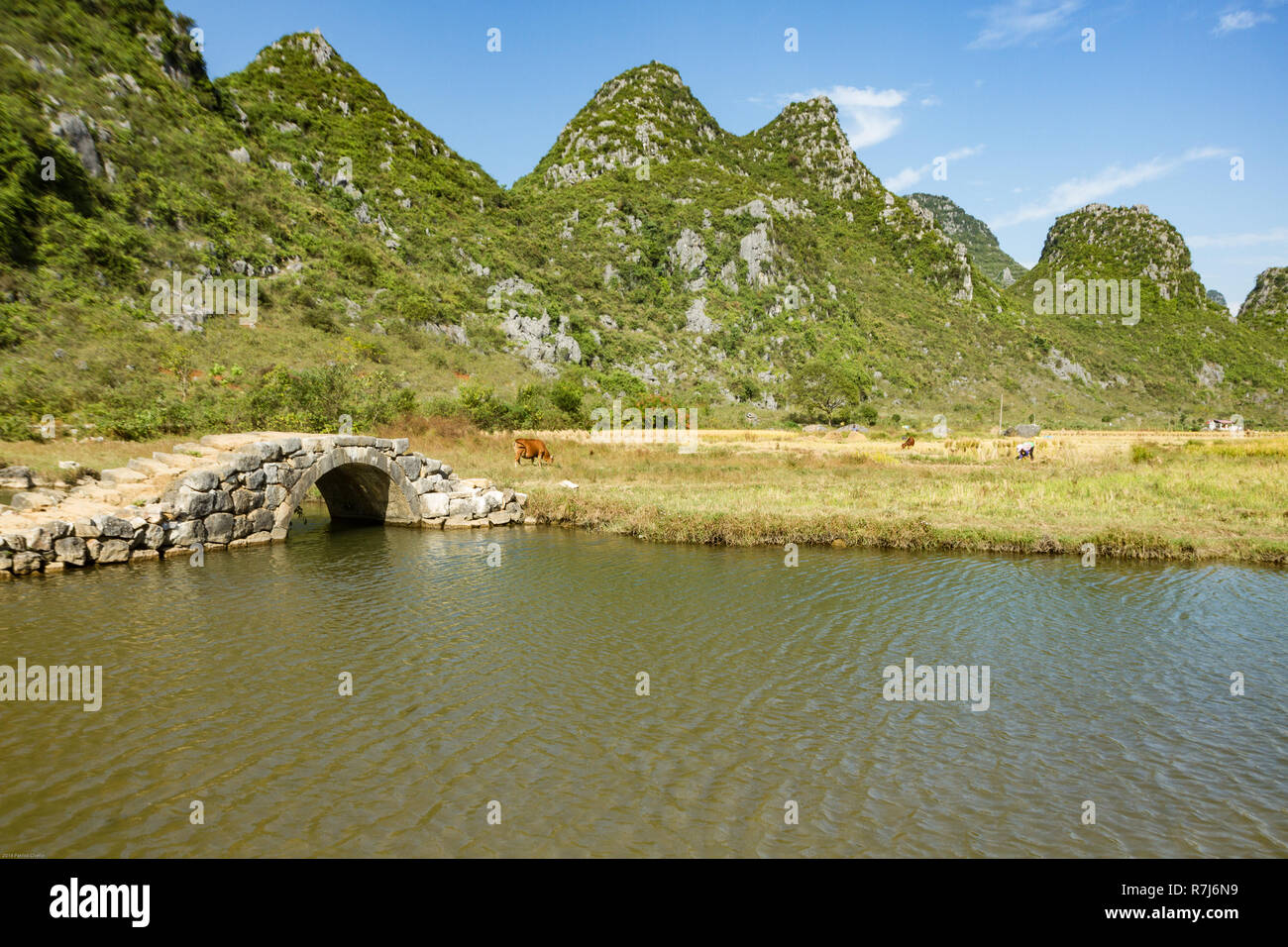 Stone bridge in picturesque valley surrounded by karst limestone hills ...