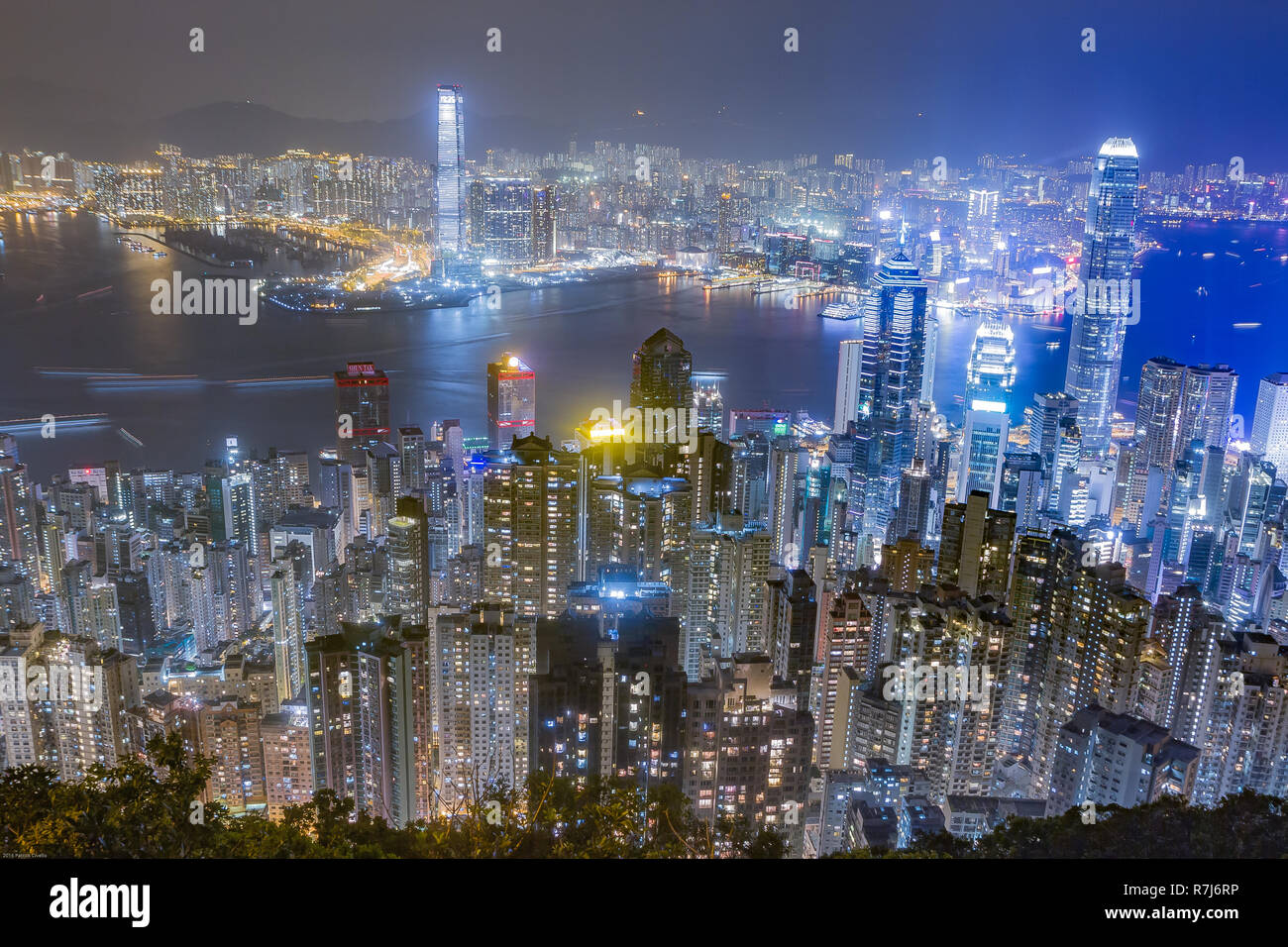 Hong Kong skyline at night as seen from Victoria Peak. Illuminated skyscrapers in foreground ...